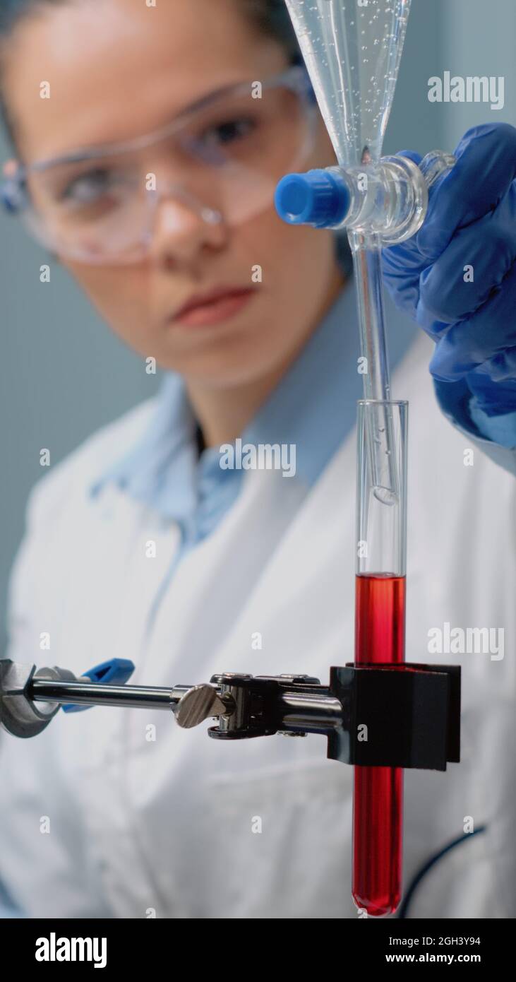 Close up of scientist using laboratory glassware on desk for medical ...