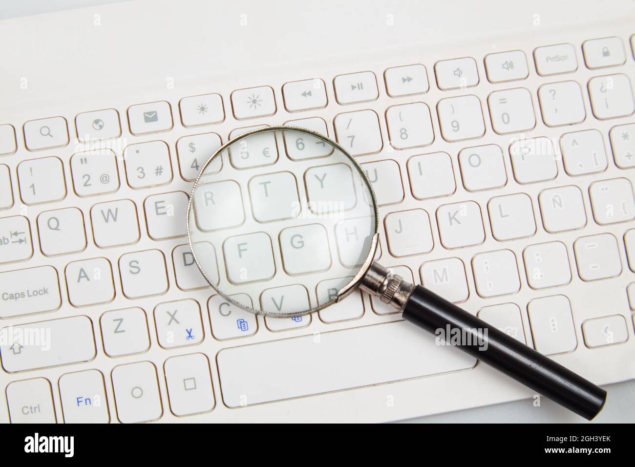 Magnifying glass on a keyboard. Business and cyber security concept ...