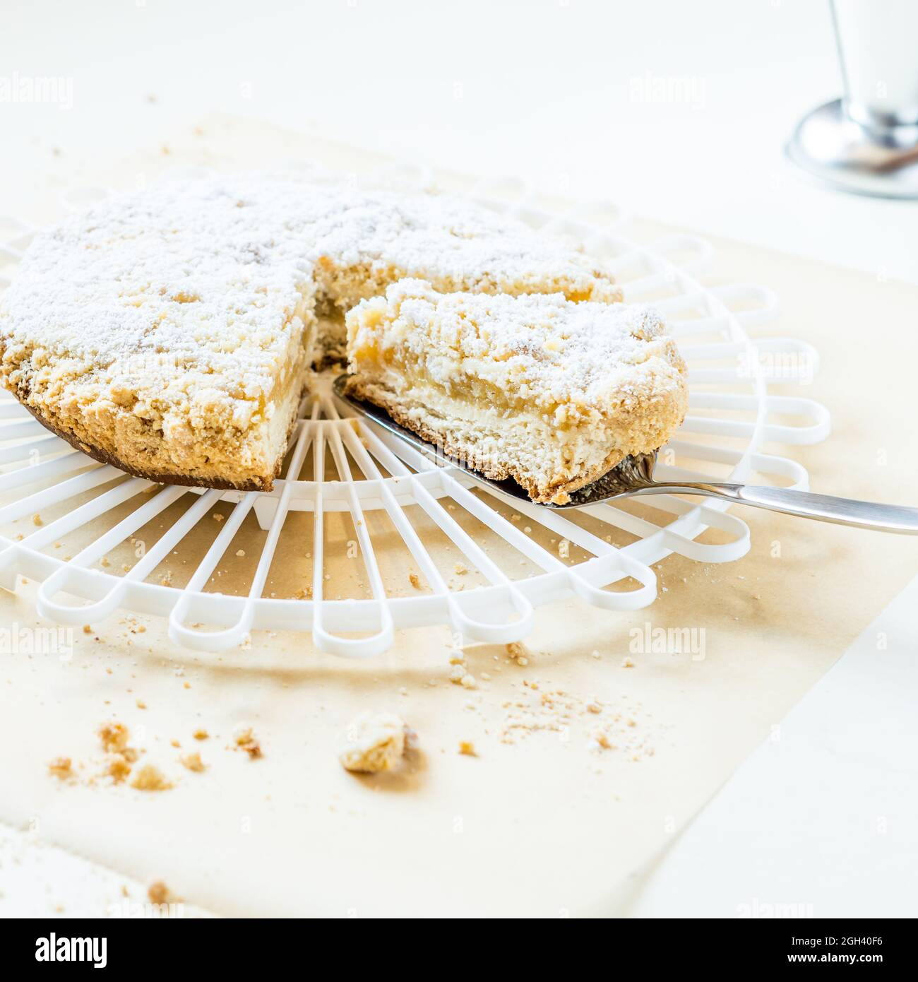 round apple crumble with icing sugar, served on a white cake grid Stock ...