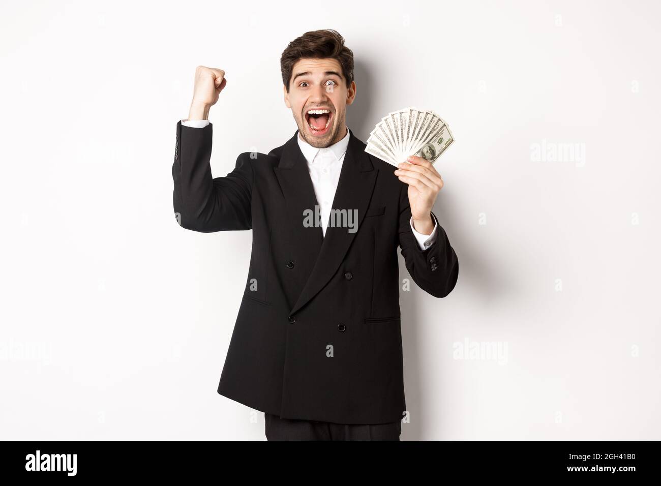 Portrait of handsome businessman in black suit, winning money and ...