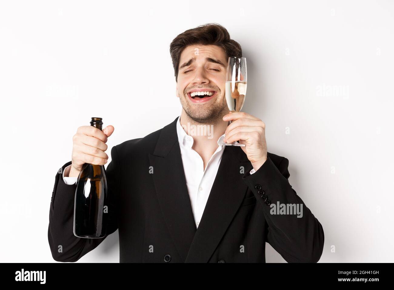 Close-up of handsome drunk guy in suit, holding glass of champagne and ...
