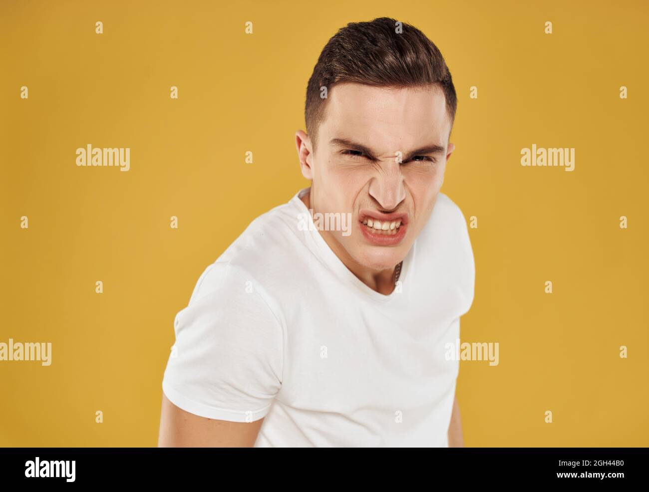 man with serious expression anger displeasure studio yellow background ...