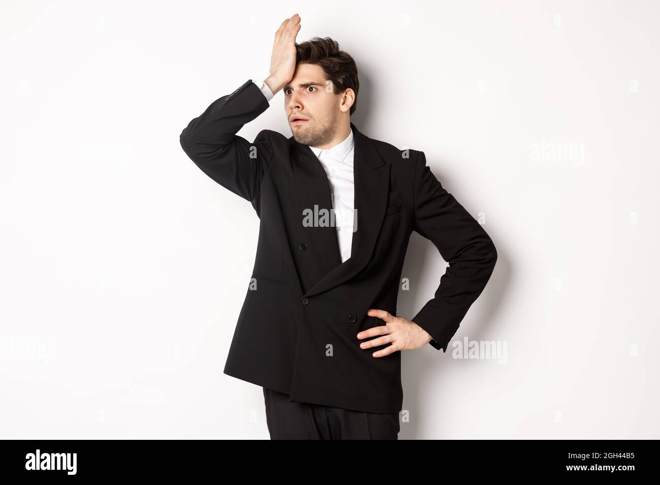 Portrait of shocked and distressed businessman in black suit, slap ...