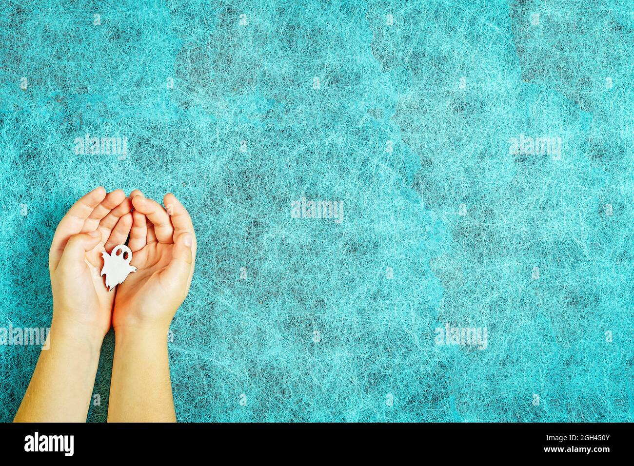 Holiday helloween on a cobweb background with a ghost in the hands of a ...