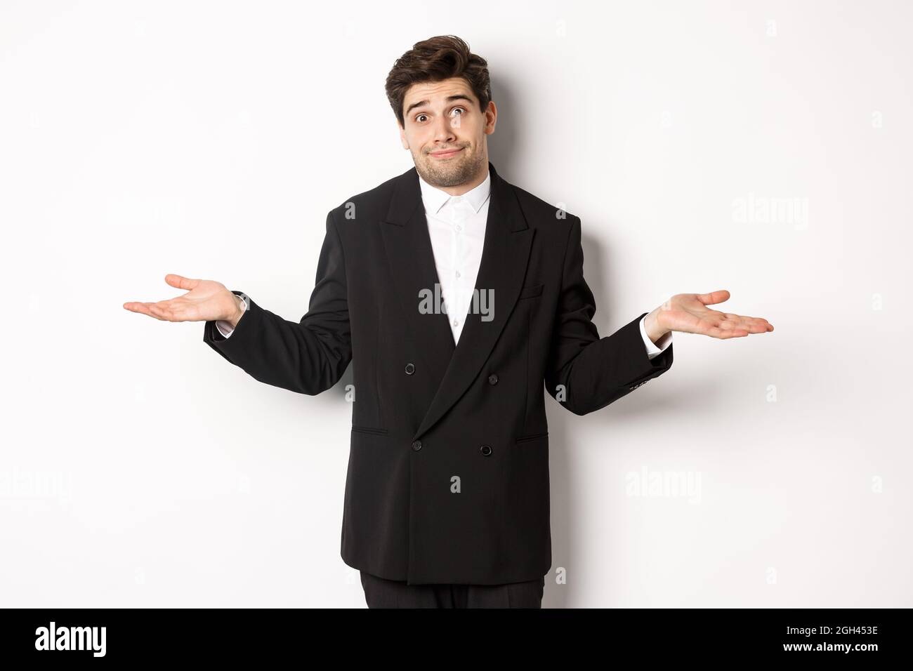 Image of handsome confused man in black suit, shrugging and looking ...