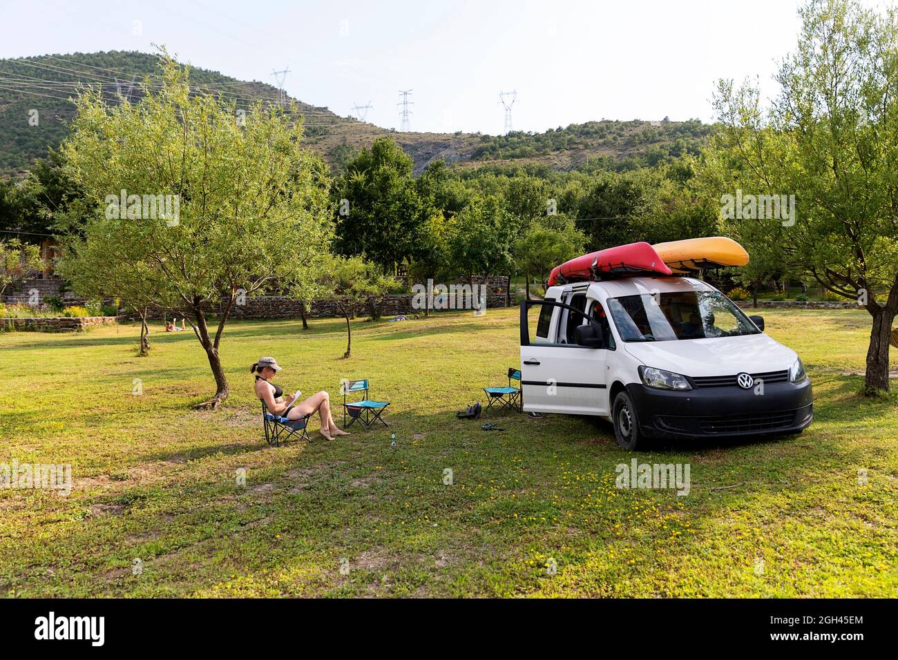 A tourist relaxing in a campsite on the shore of a Vau Dejes reservoir ...