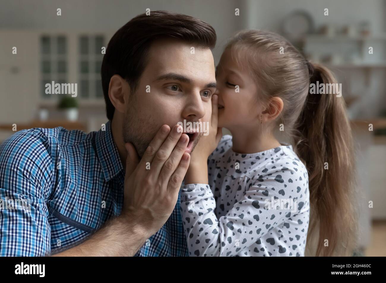 Cute daughter girl telling secret to excited surprised dad Stock Photo ...