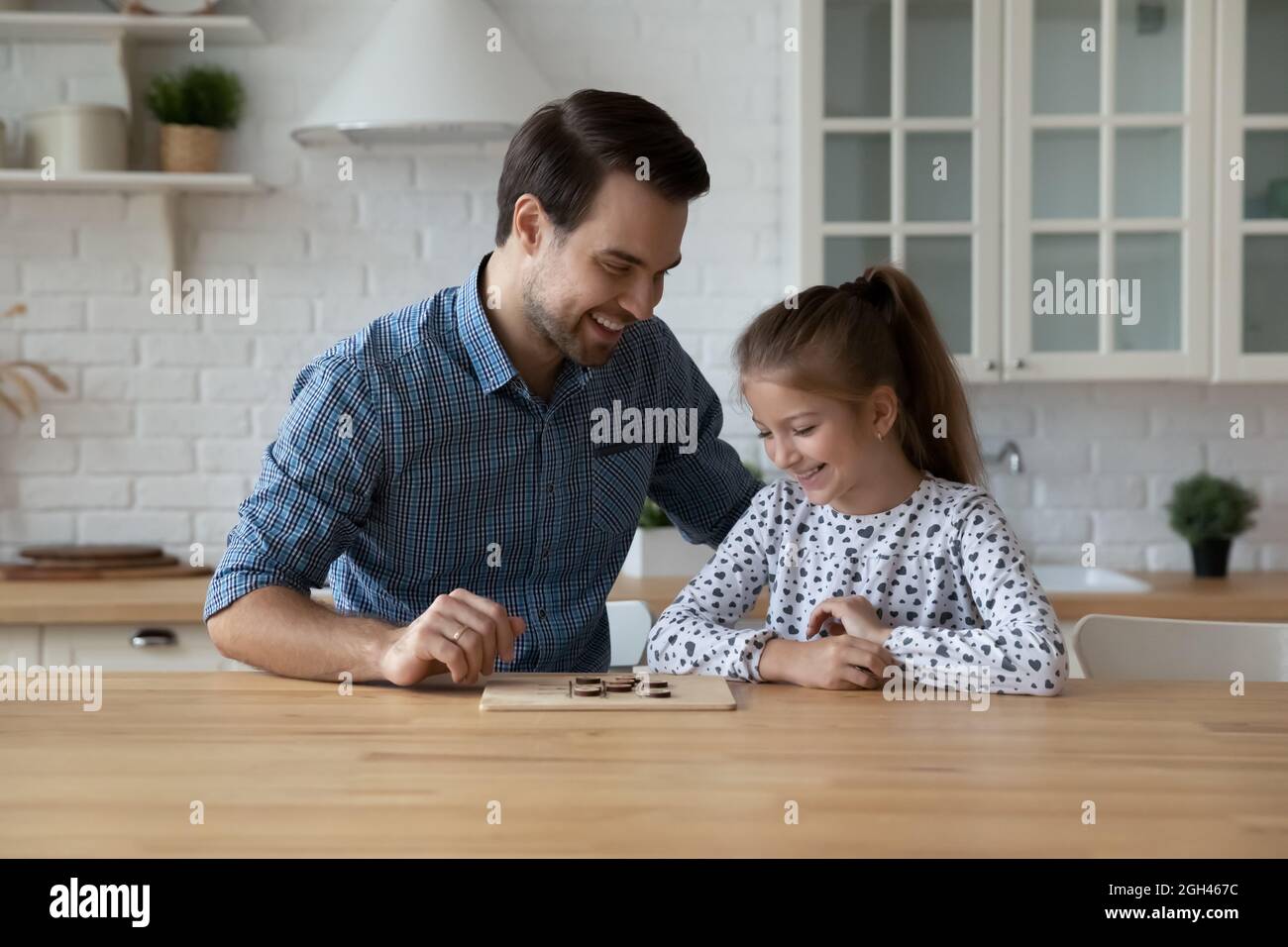 Happy dad teaching daughter kid to play learning board game Stock Photo ...