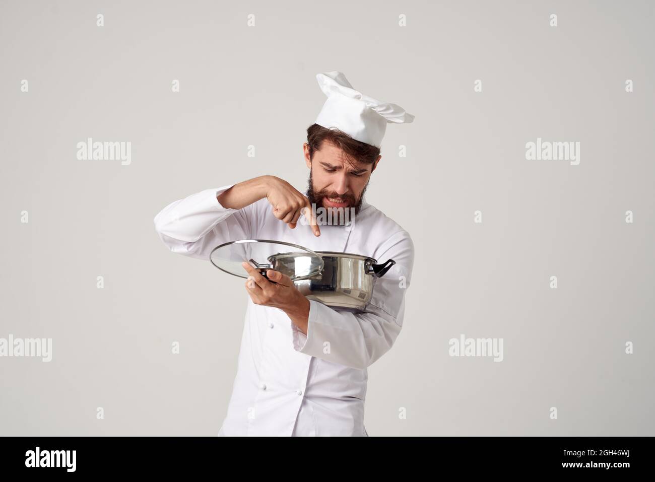 professional chef tastes food with a pan in his hands restaurant light ...
