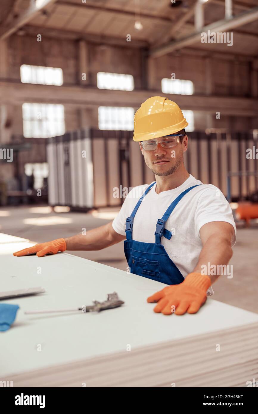 Handsome male worker standing by building materials Stock Photo - Alamy