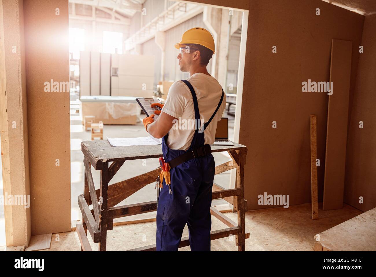 Male worker writing on clipboard at construction site Stock Photo - Alamy