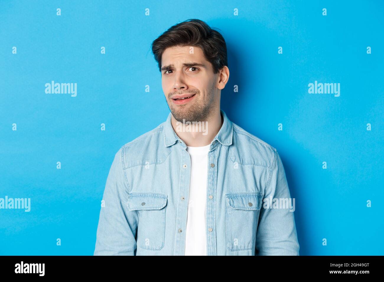 Confused and uncomfortable man looking at something strange or creepy ...