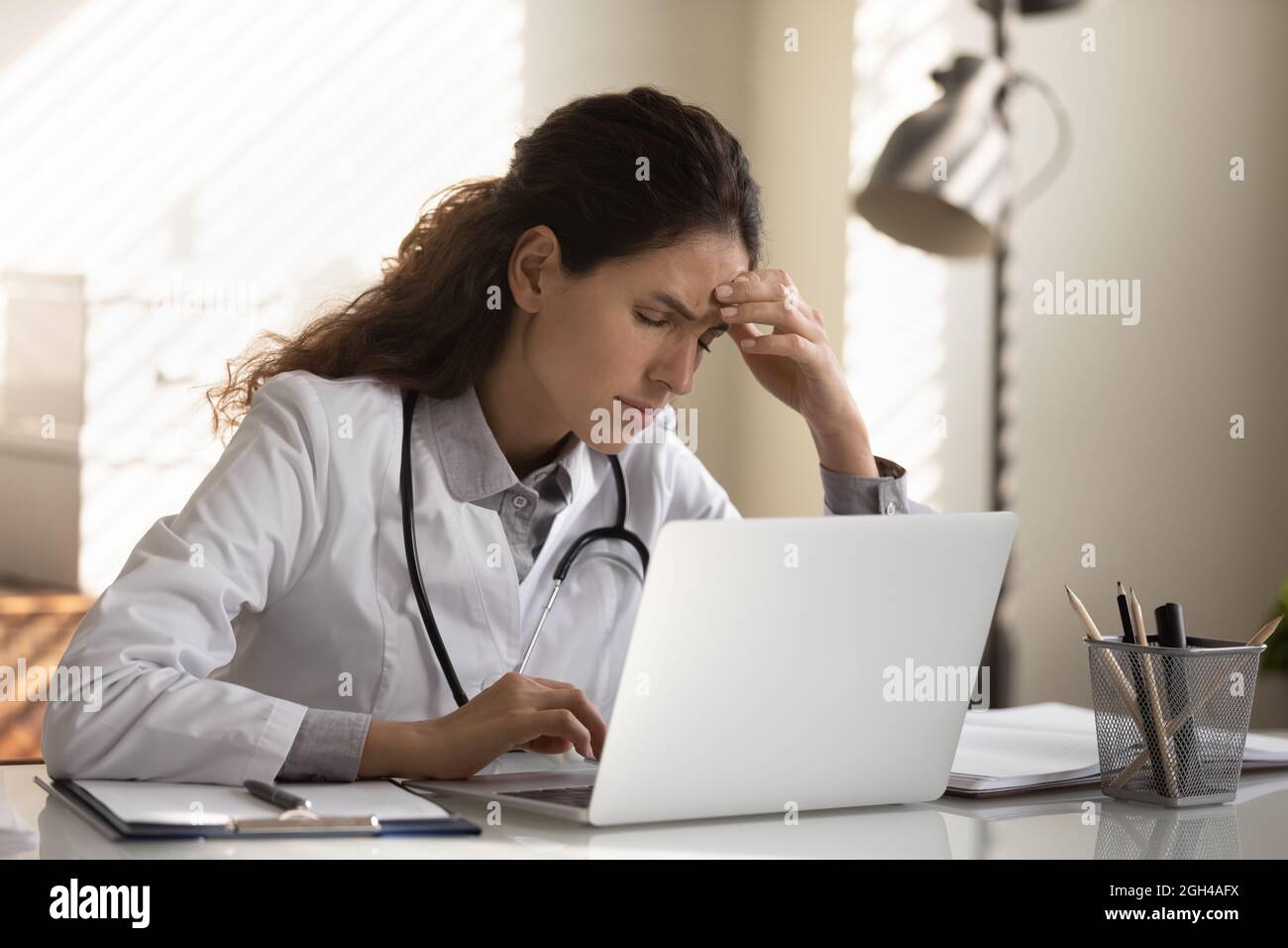 Tired frustrated female doctor feeling stress at workplace Stock Photo ...