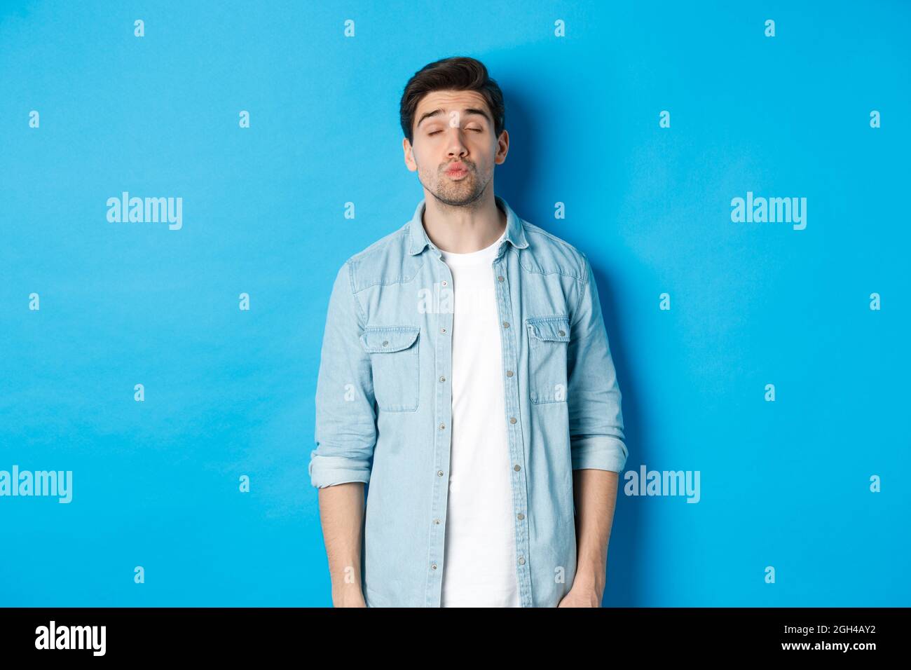 Handsome man waiting for kiss, pucker lips and close eyes while ...