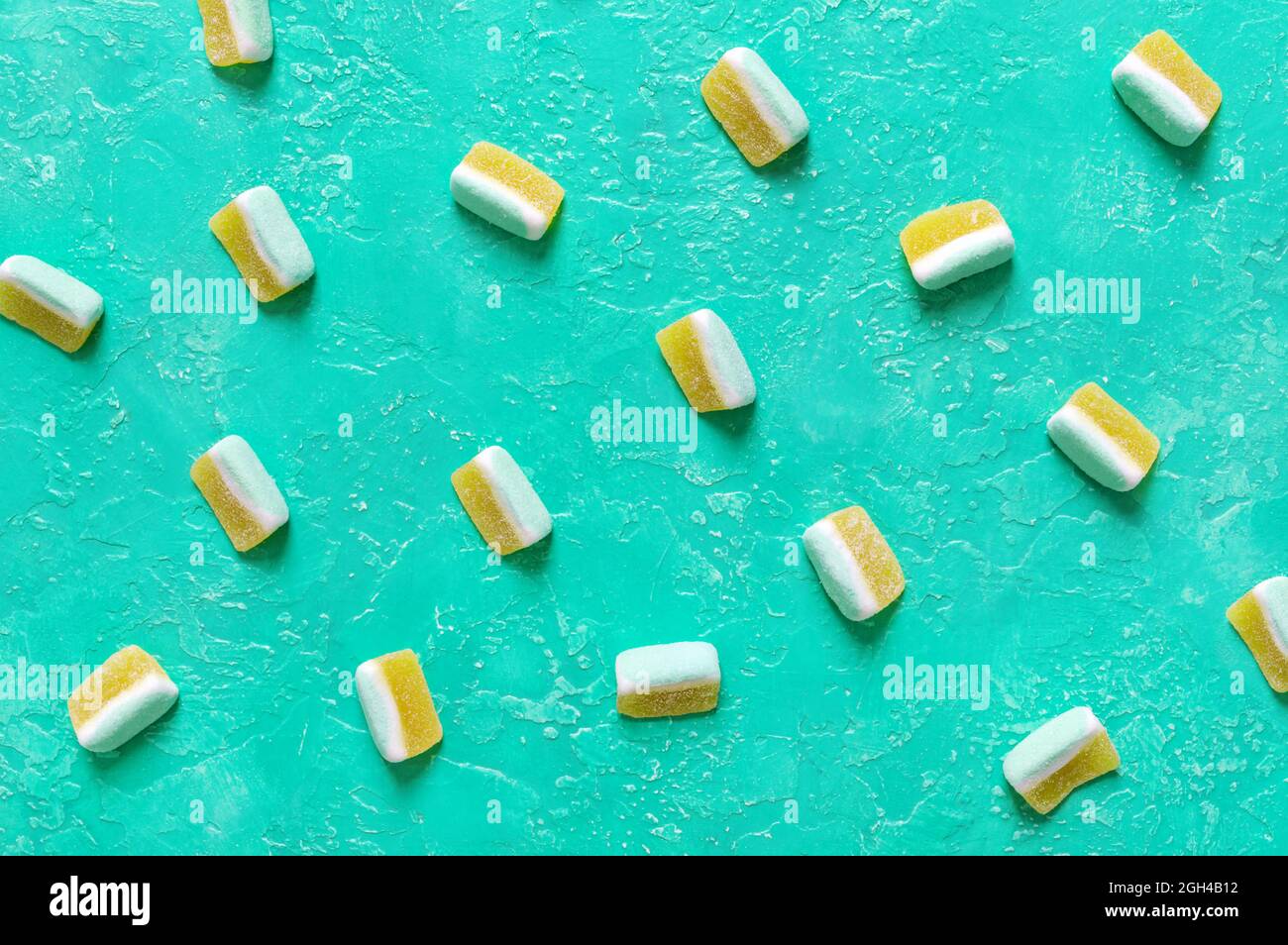 Fruit jelly candies in the form of melon slices on a bright turquoise ...