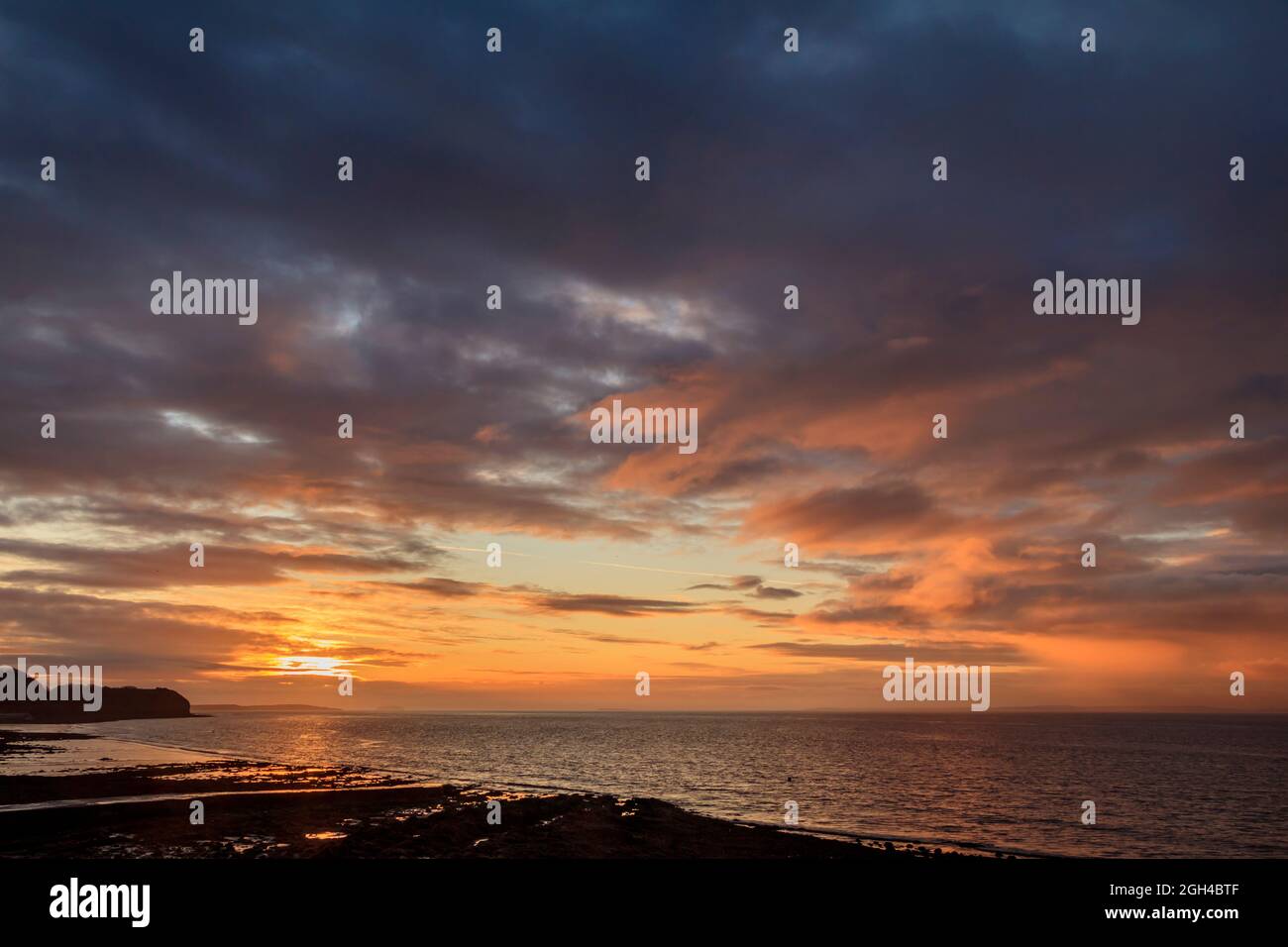 The setting sun lighting up the cloud-cover Stock Photo - Alamy