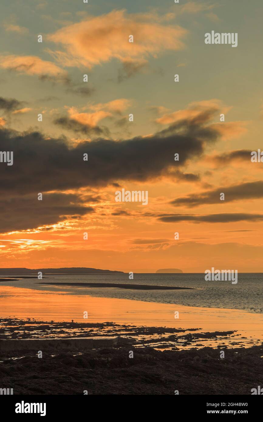 The setting sunlight reflecting onto the sea and mud Stock Photo - Alamy