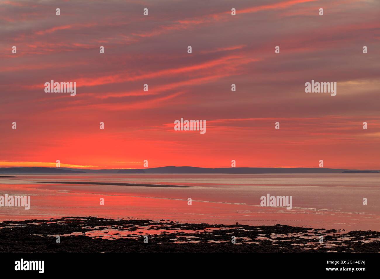The setting sunlight reflecting onto the sea and mud Stock Photo - Alamy