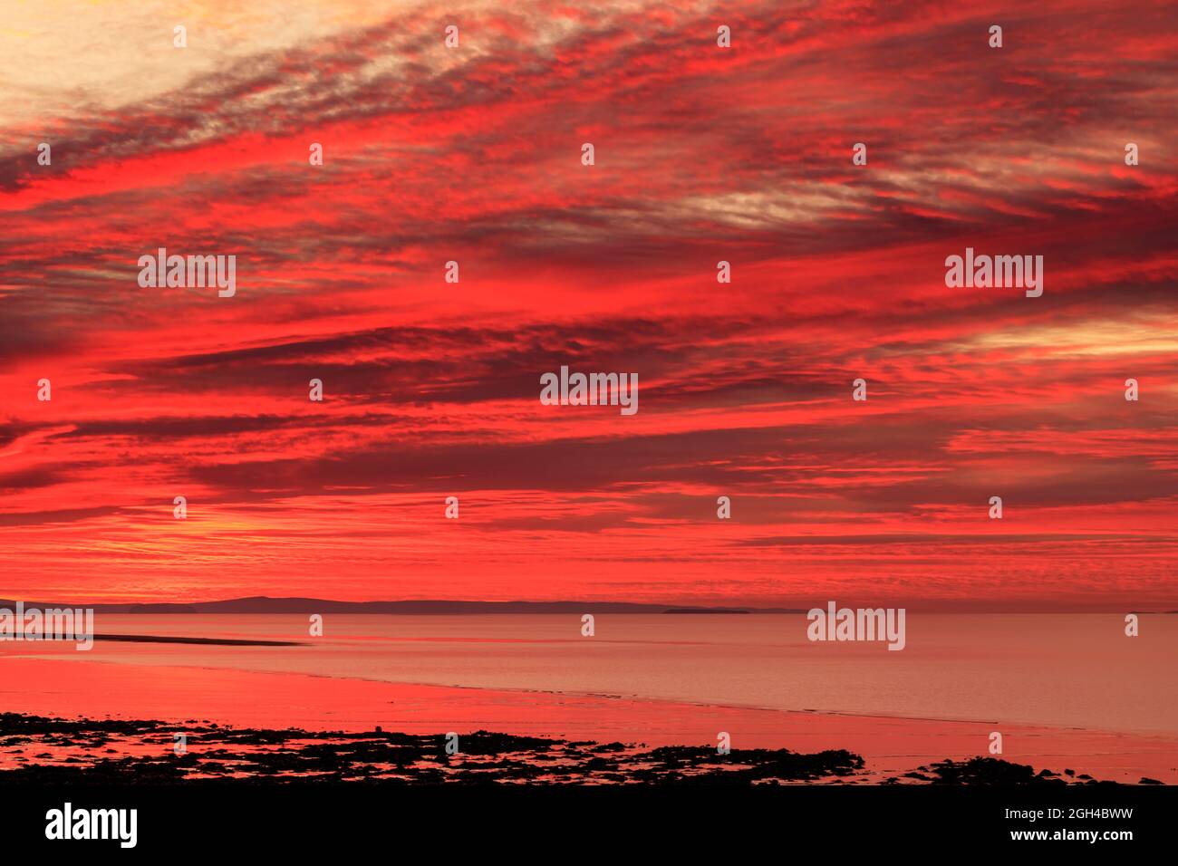 The setting sunlight reflecting onto the sea and mud Stock Photo - Alamy