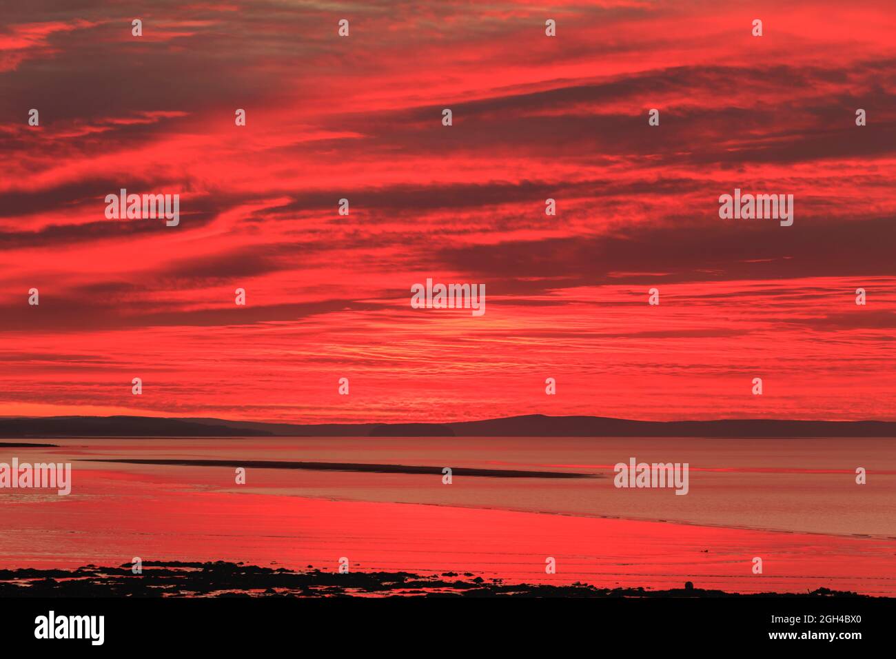 The setting sunlight reflecting onto the sea and mud Stock Photo - Alamy