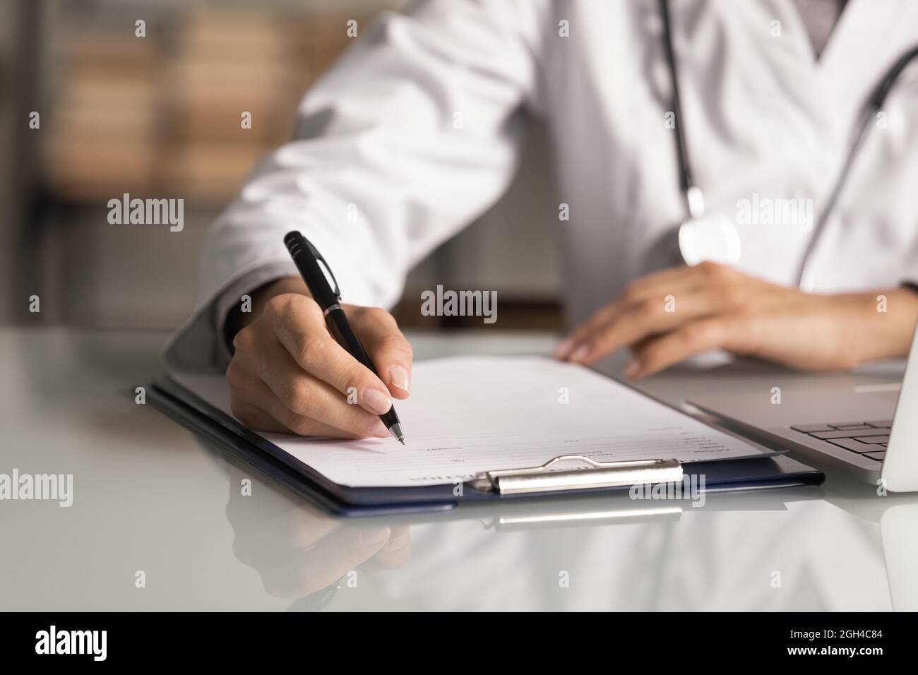 Hands of general practitioner filling paper medical records Stock Photo ...