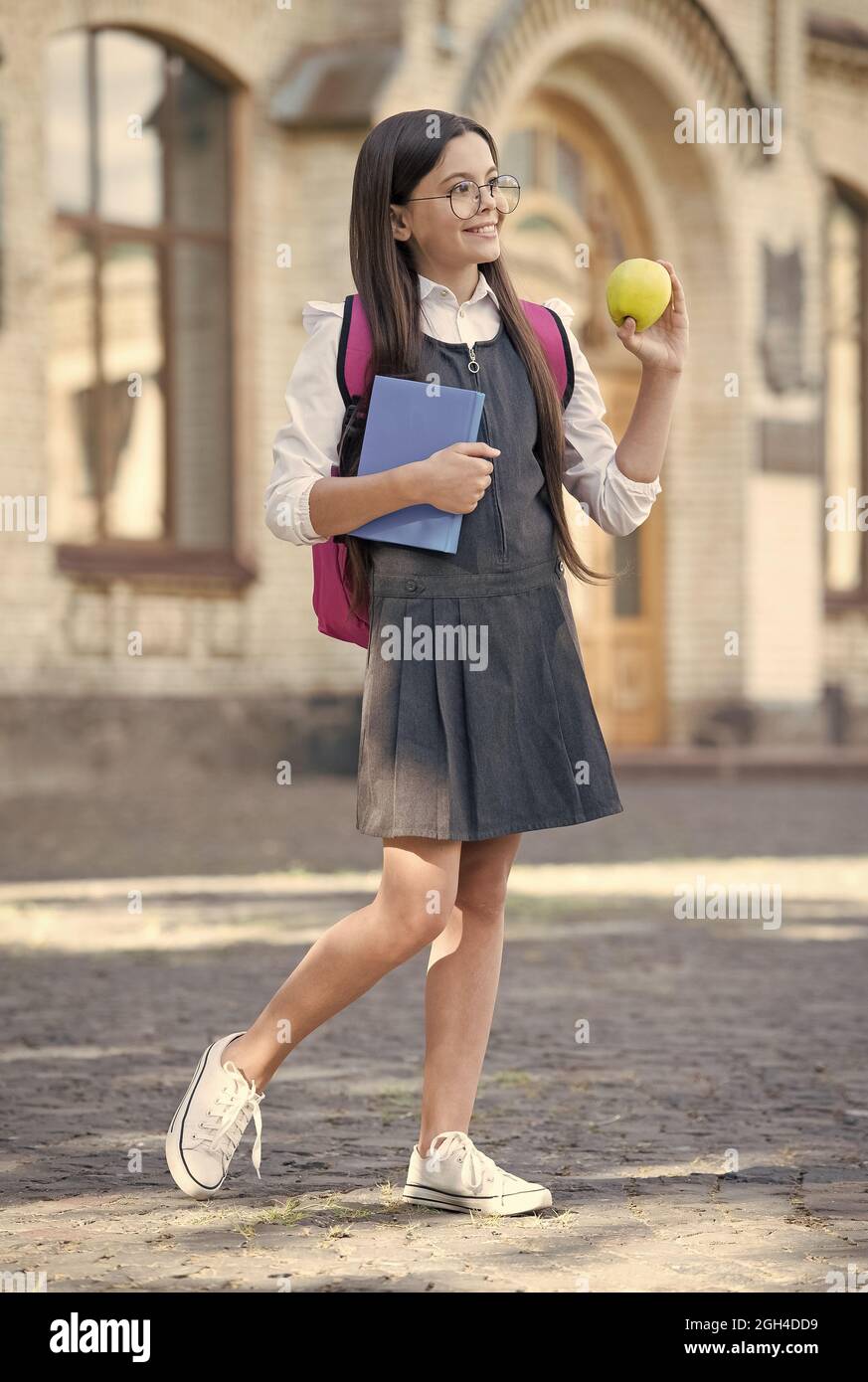 Diet makes difference to learning. Happy child hold apple and book ...