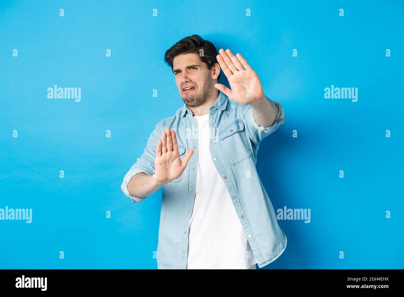 Disgusted guy saying no, refusing and looking away from something awful ...