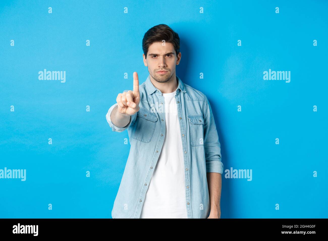 Angry 25 years old man shaking finger in disapproval sign, frowning ...