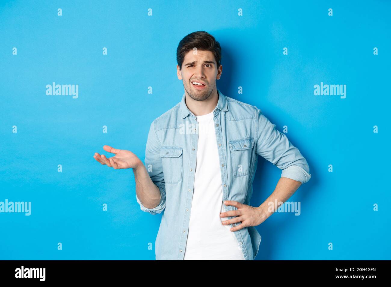 Careless man looking at something disappointing, complaining and ...