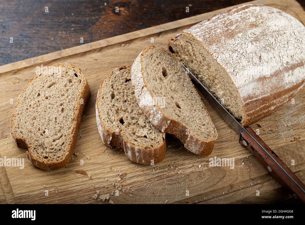 Fresh bread slice and cutting knife on rustic table Stock Photo - Alamy