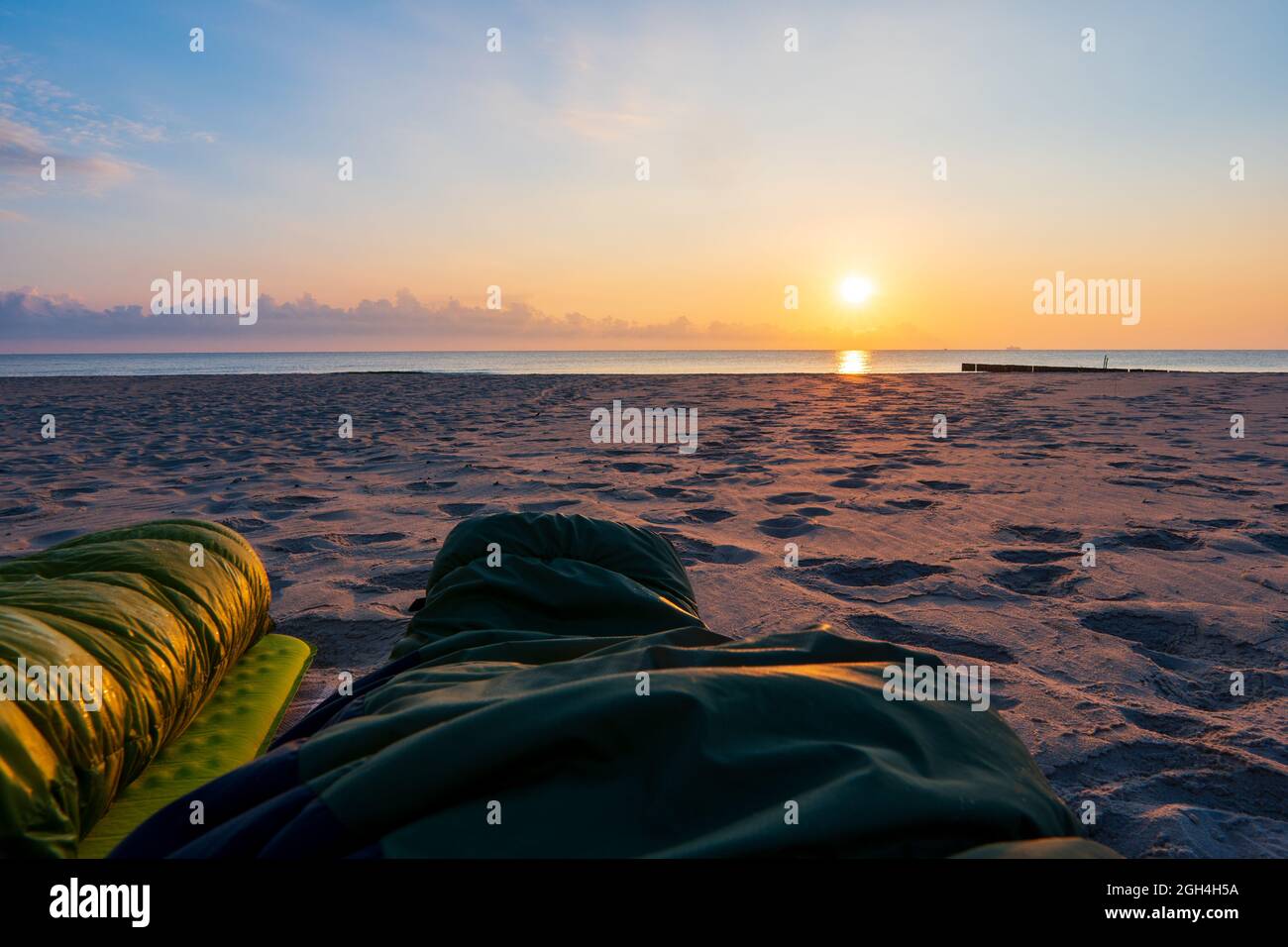 Person sleeping on beach in morning Stock Photo - Alamy
