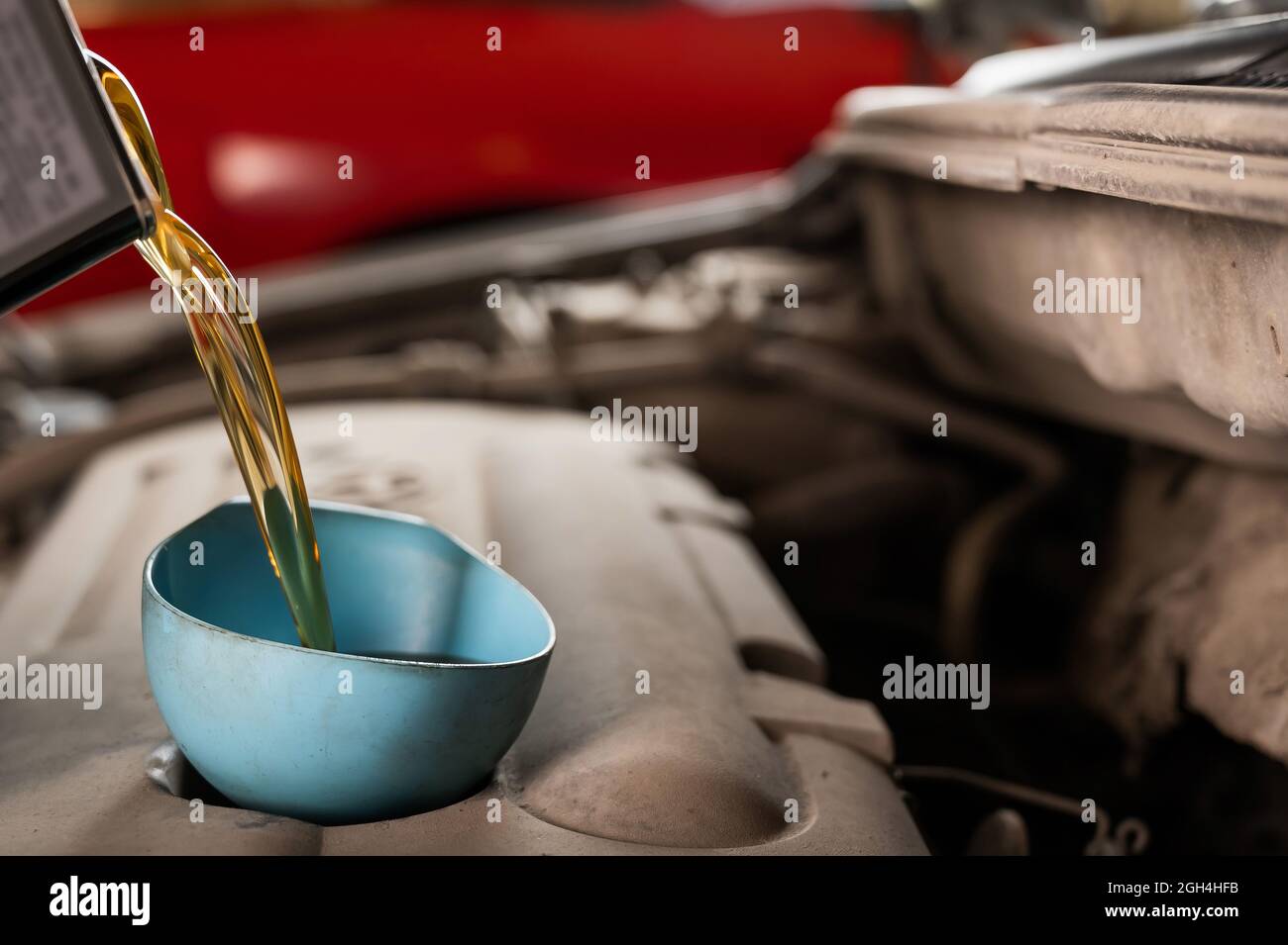 Auto mechanic pours oil into a car engine Stock Photo - Alamy