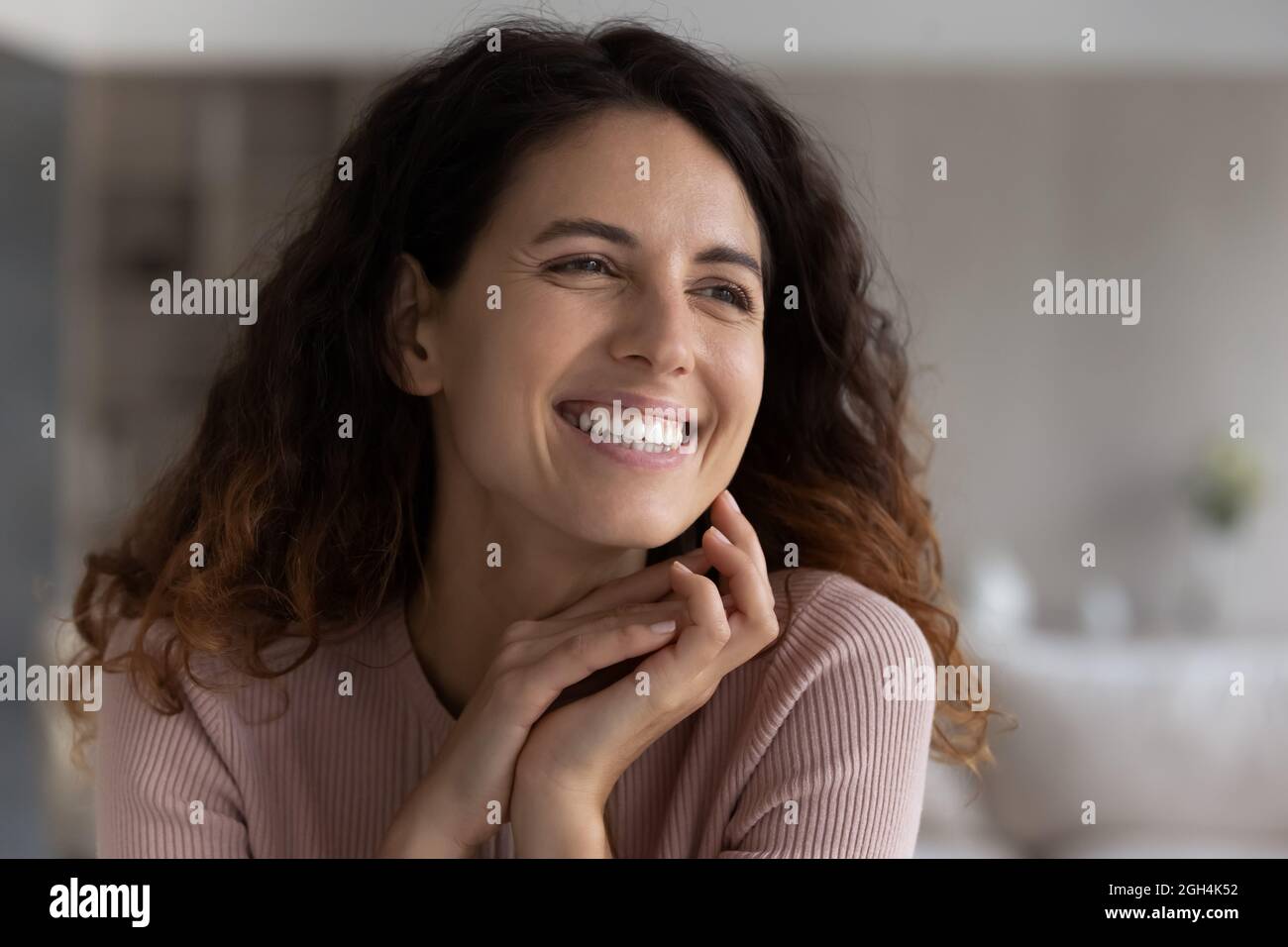 Joyful attractive young latin woman daydreaming, looking in distance ...