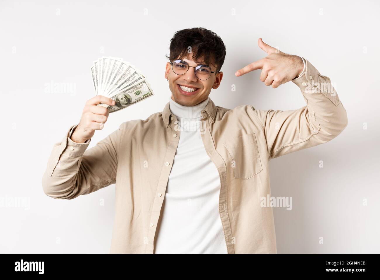 Cool handsome guy show-off, pointing at dollar bills and smiling ...