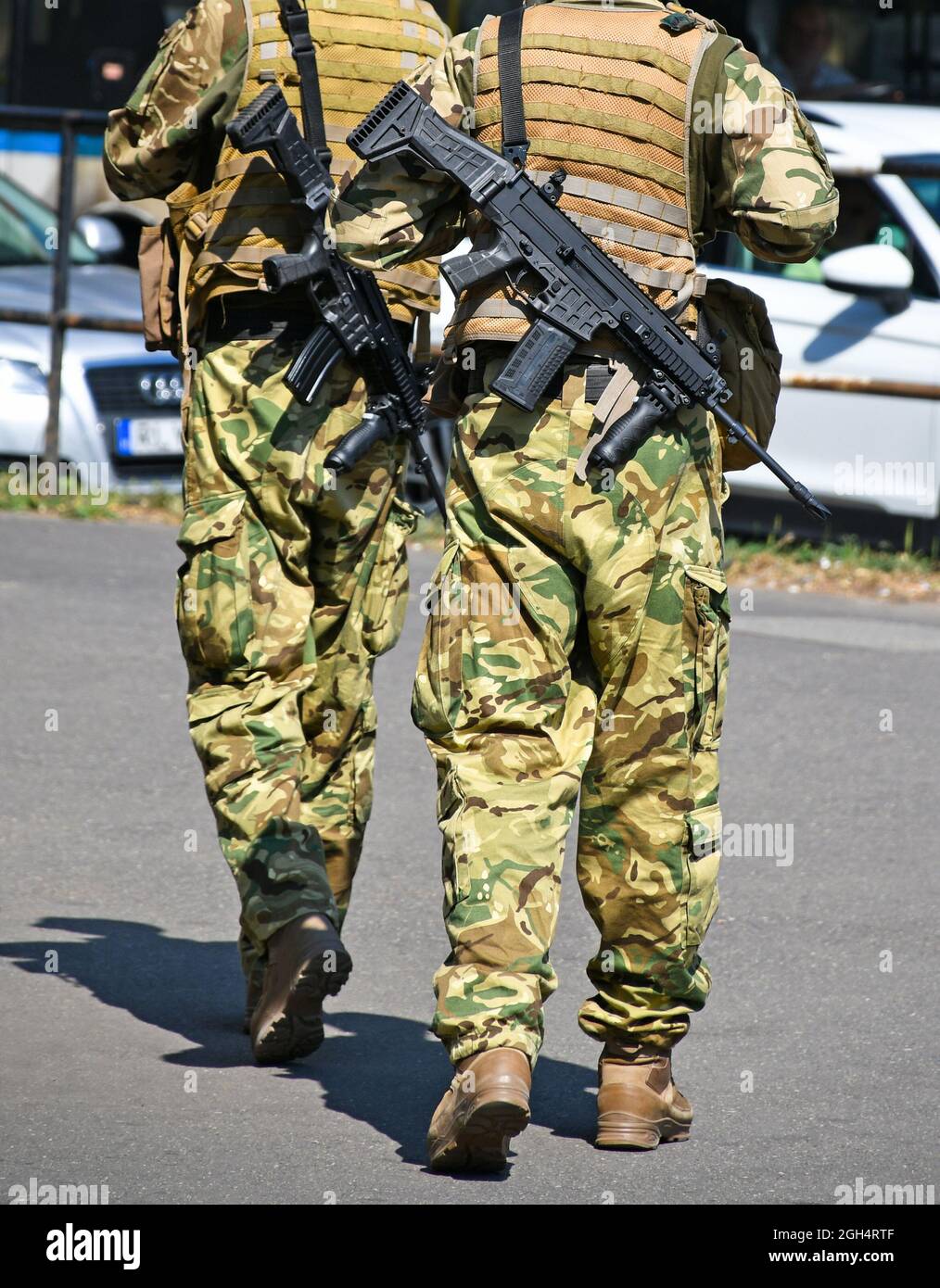 Soldiers with machine guns walking on the street Stock Photo - Alamy
