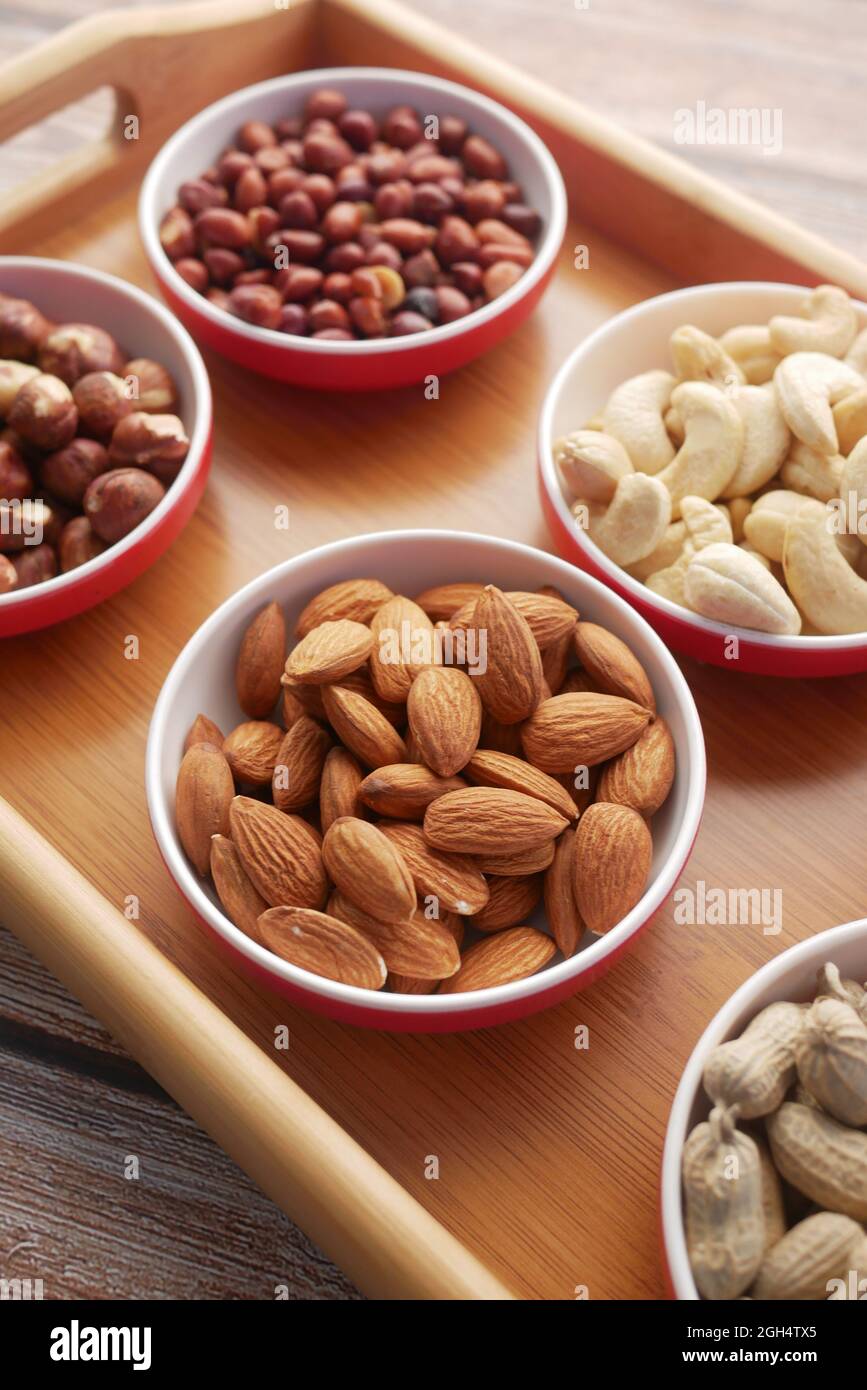 peanut, hazelnut walnut , cashew nut and almond in a container on black ...