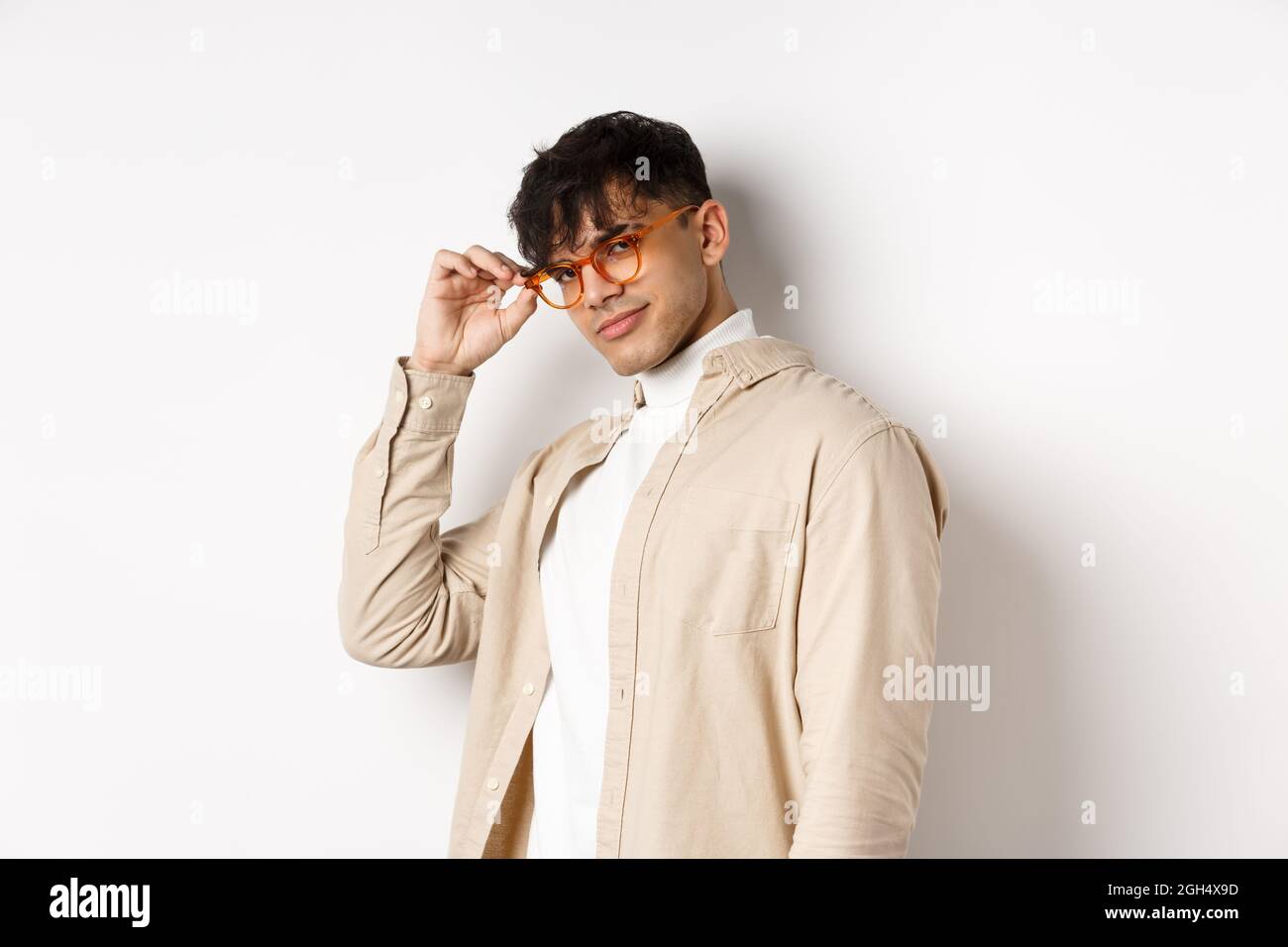 Handsome stylish guy saluting you, touching eyewear and smiling sassy ...