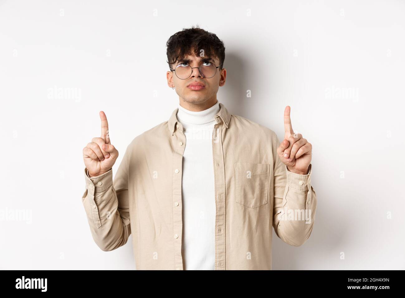 Image of annoyed or offended young man looking, pointing fingers up ...