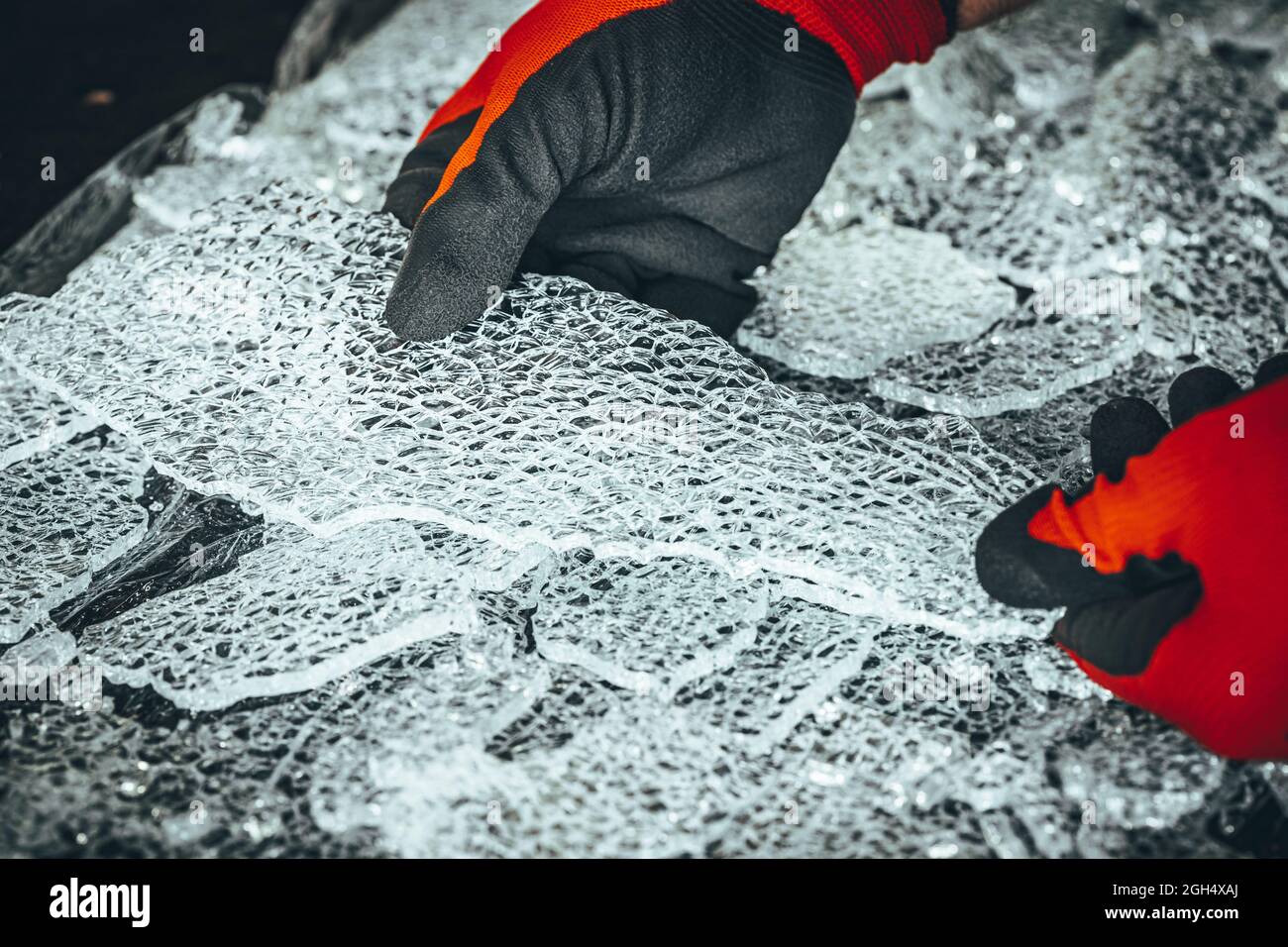 Pieces of broken toughened glass, hands in gloves Stock Photo - Alamy