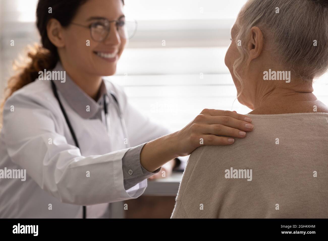 Happy general practitioner telling good optimistic news to older ...