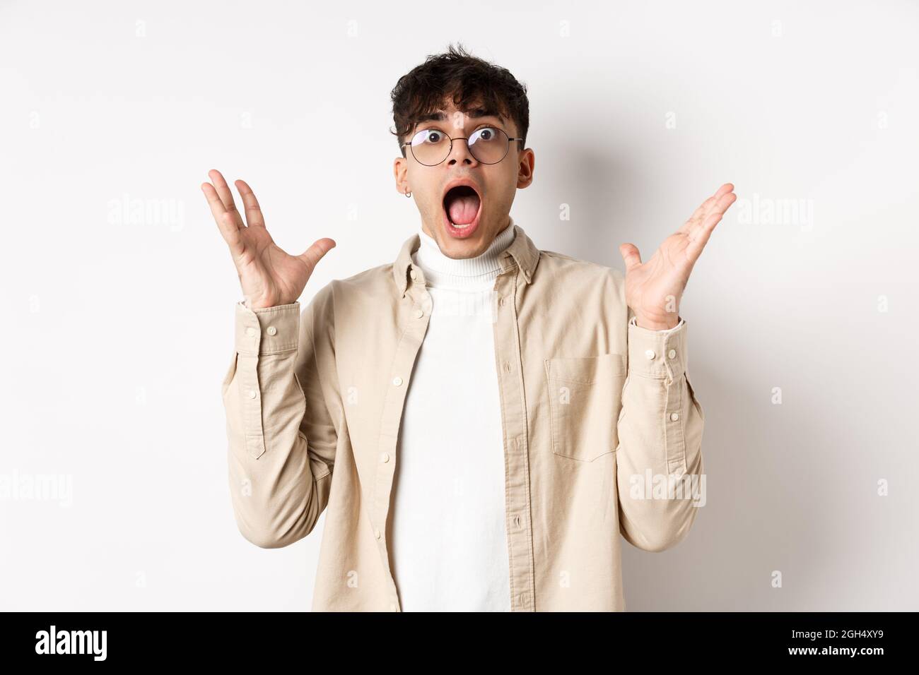 Scared young man in panic, screaming and looking axious, jumping ...