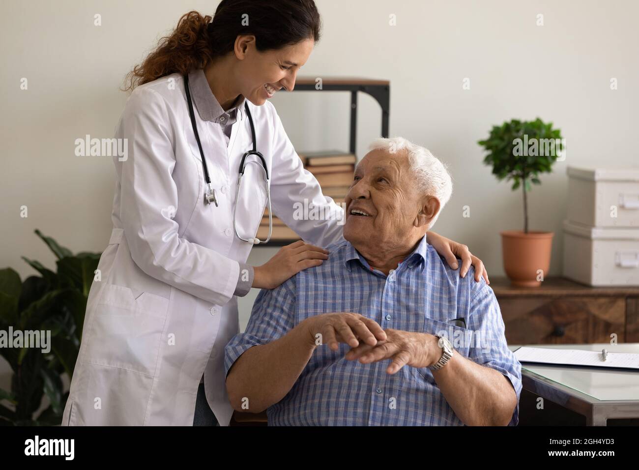 Happy doctor giving hug and support to optimistic old patient Stock ...