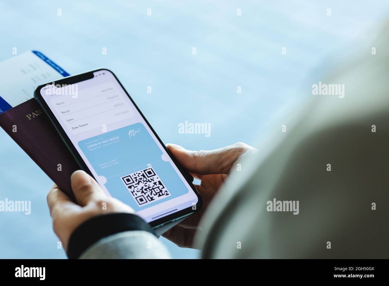Closeup of a female passenger with digital medical pass on her mobile ...