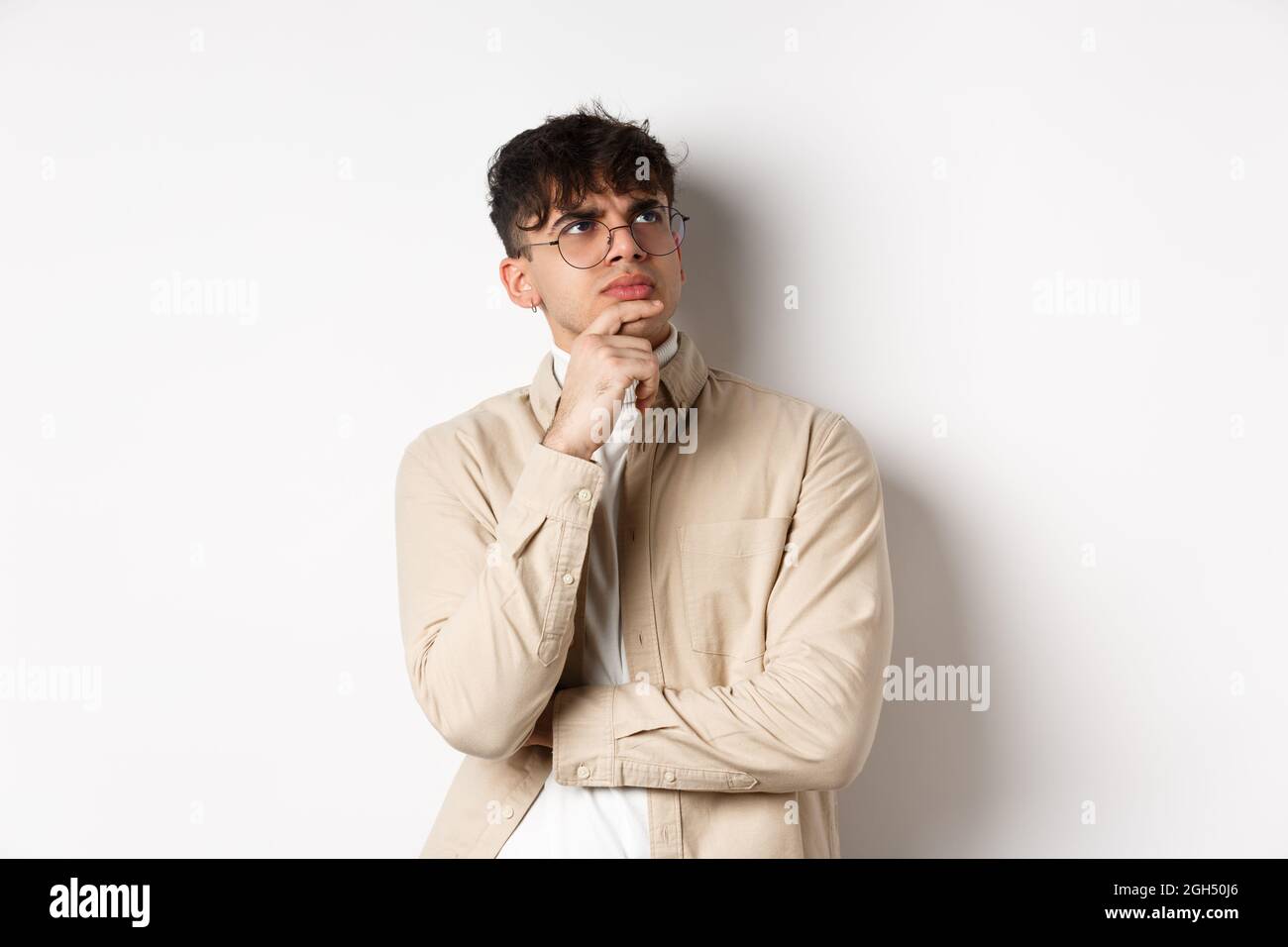 Handsome hipster guy in glasses look pensive at empty space, touching ...