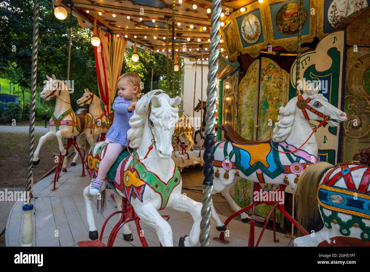 Cute baby girl on the horse of old retro carousel, Prague, Czech ...