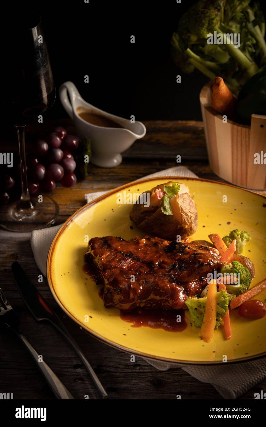pork barbeque on a yellow plate with vegetable Stock Photo - Alamy
