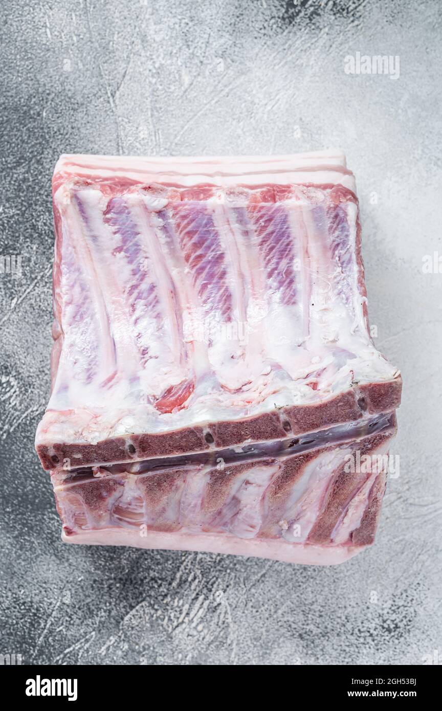 Raw whole rack of pork loin with ribs on kitchen table. White ...