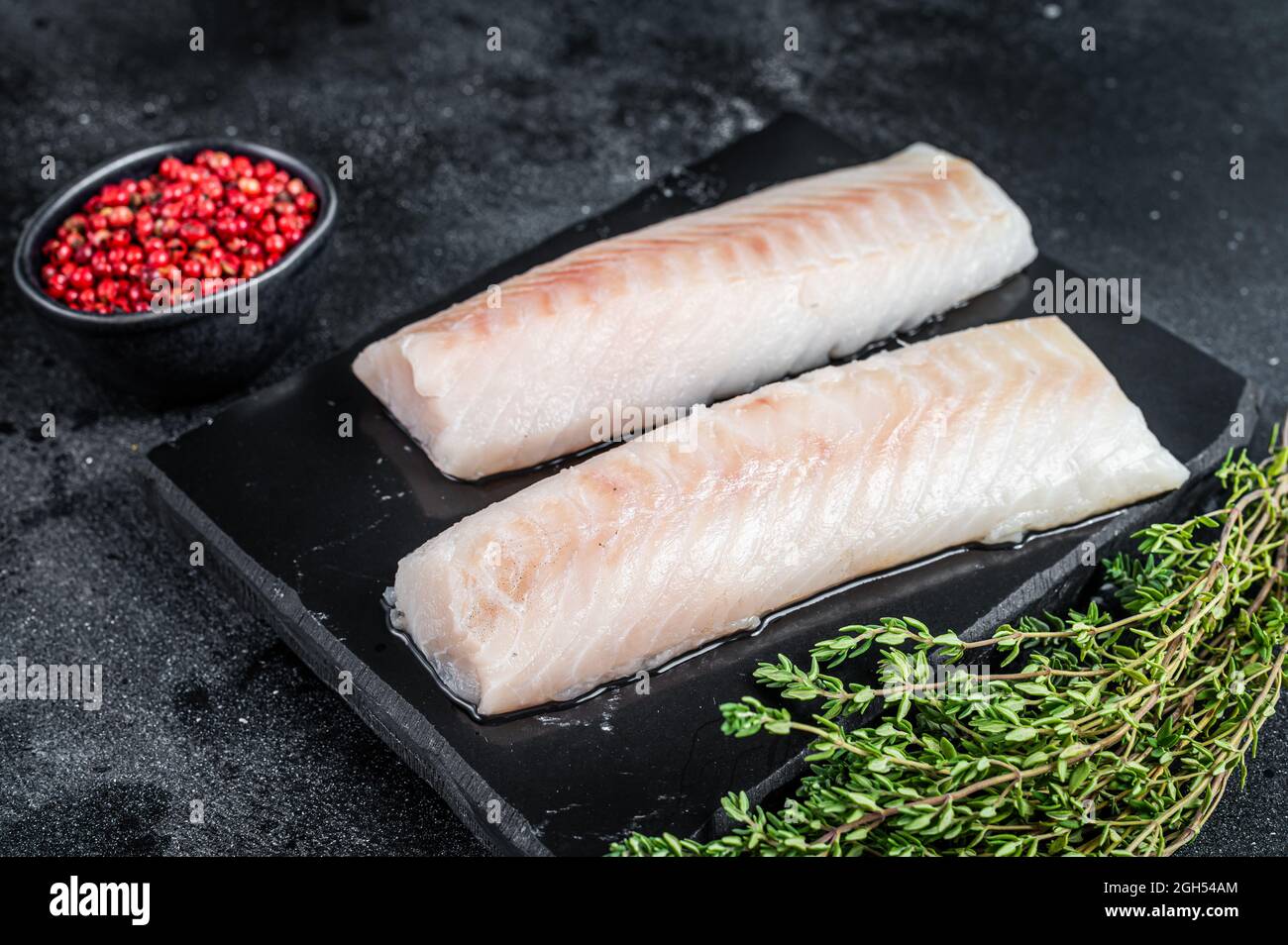 Raw cod loin fillet fish on marble board. Black background. Top view ...
