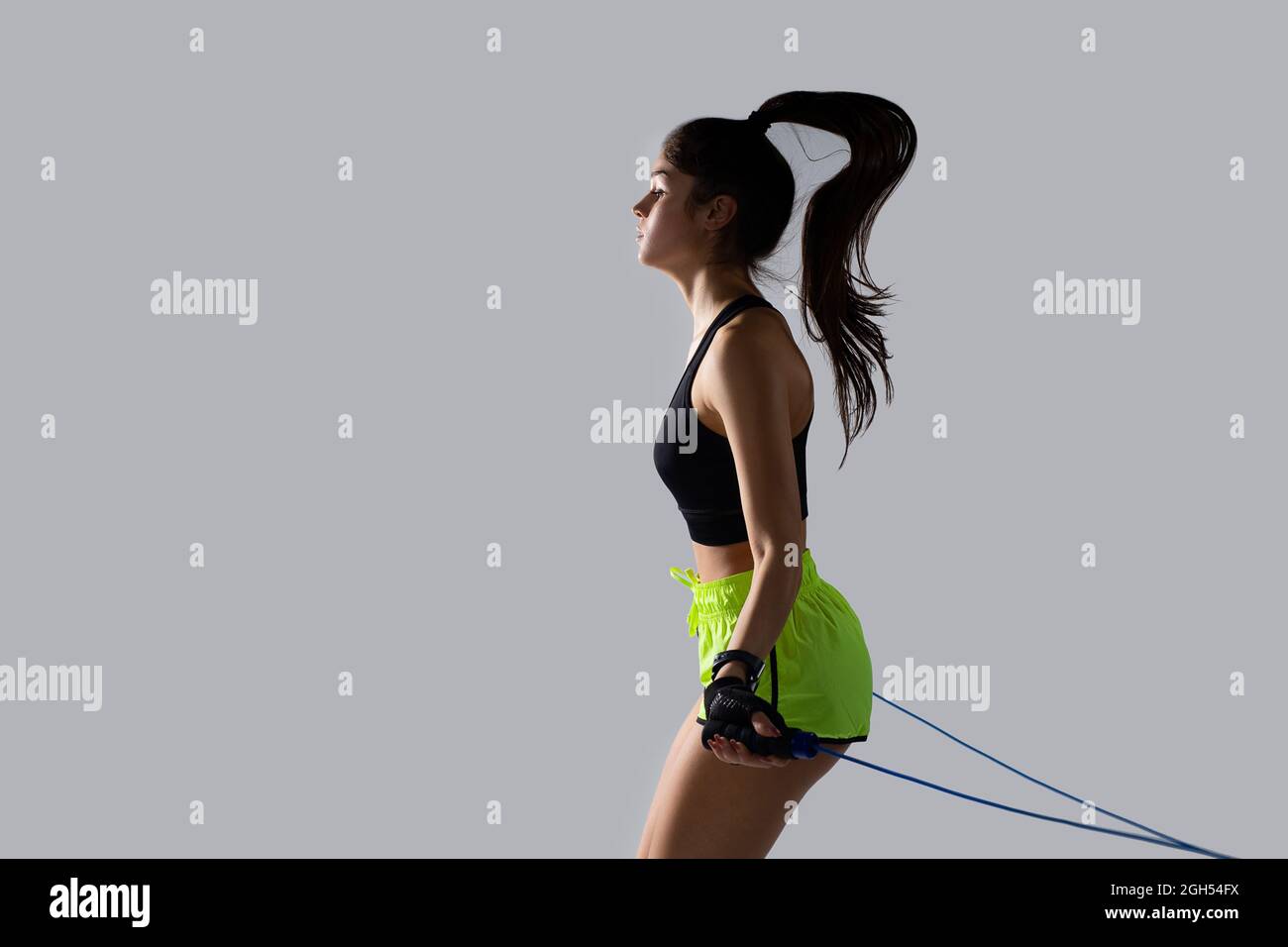 Photo of a sporty girl exercising with skipping rope moving dynamic ...