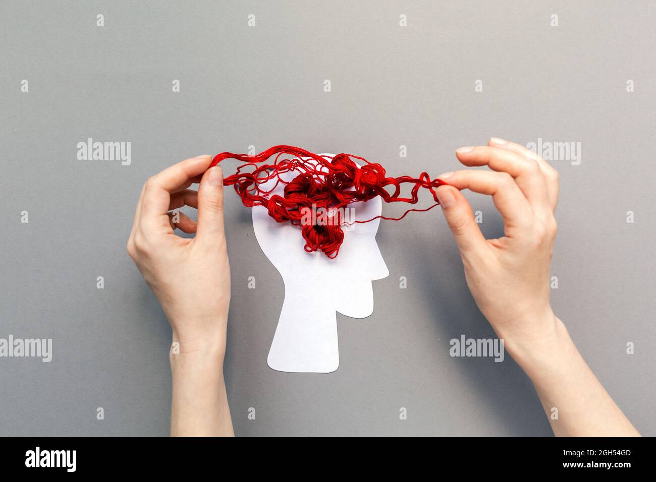 Tangled red threads on the silhouette of the head, representing the ...